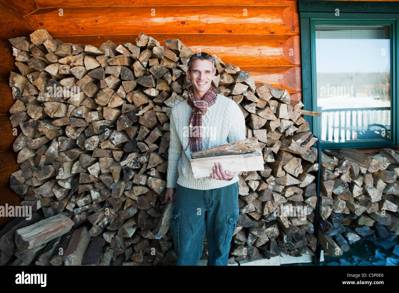 Man holding logs, portrait Stock Photo - Alamy