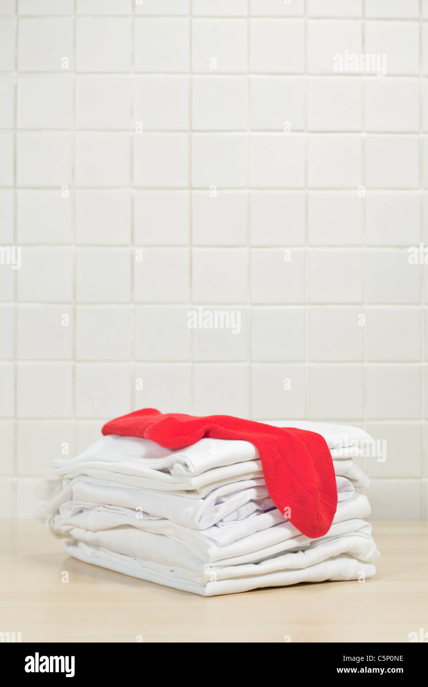 Piles of clean white laundry and red sock Stock Photo - Alamy