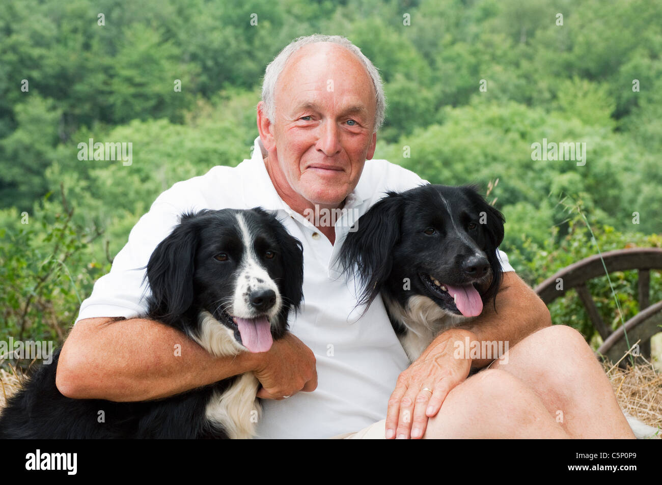 Senior man holding two dogs, portrait Stock Photo - Alamy