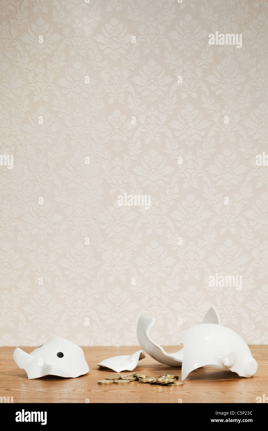 Smashed piggy bank and coins Stock Photo - Alamy