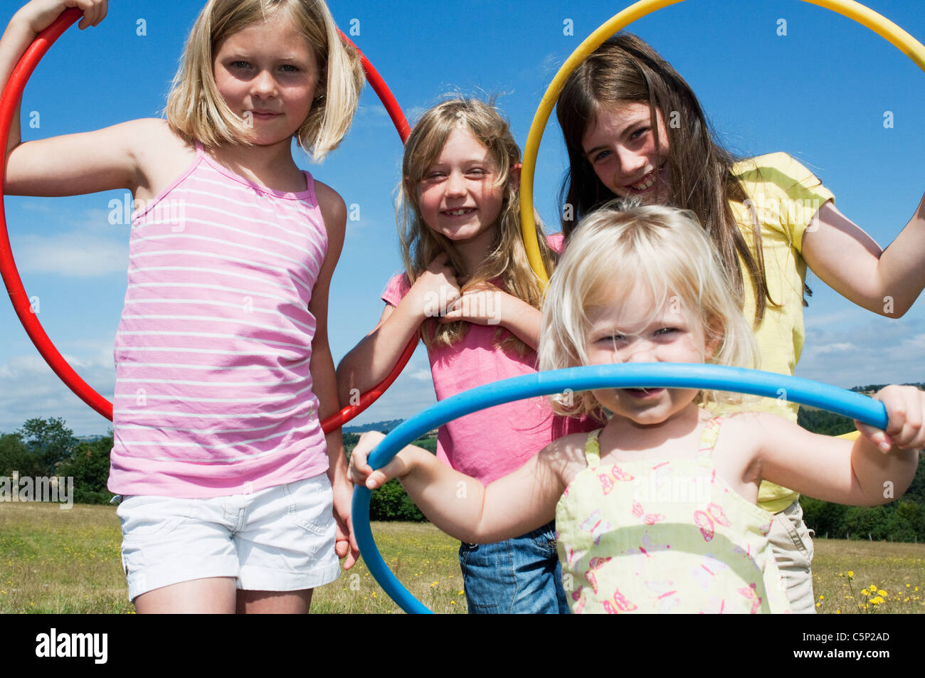 Four girls with plastic hoops, portrait Stock Photo - Alamy