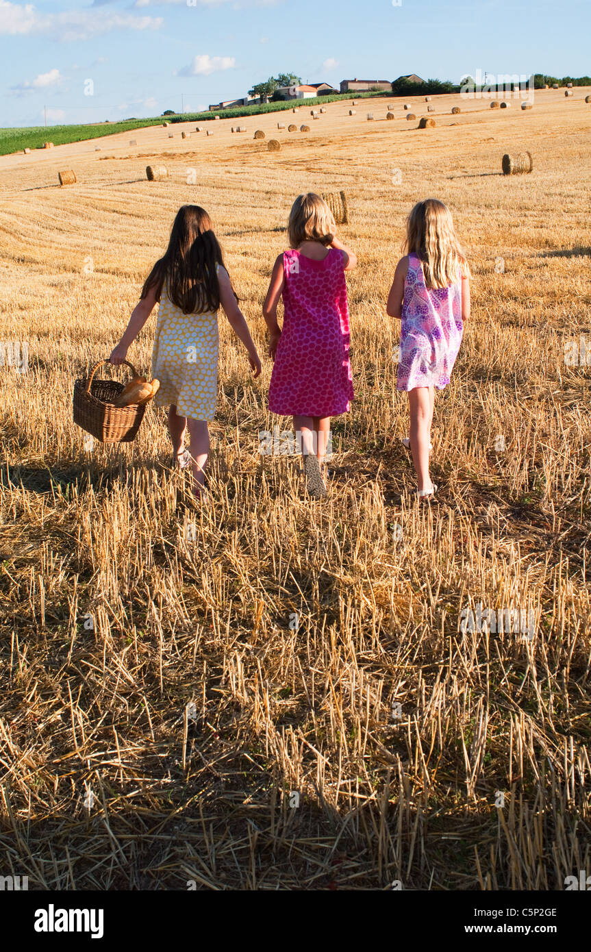 Three girls walking in field Stock Photo - Alamy