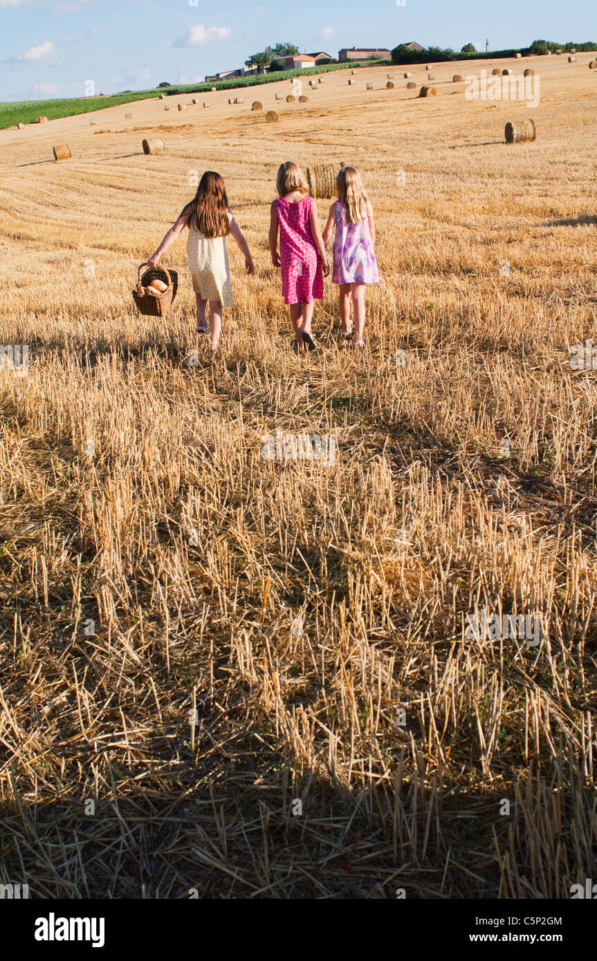 Three girls walking in field Stock Photo - Alamy