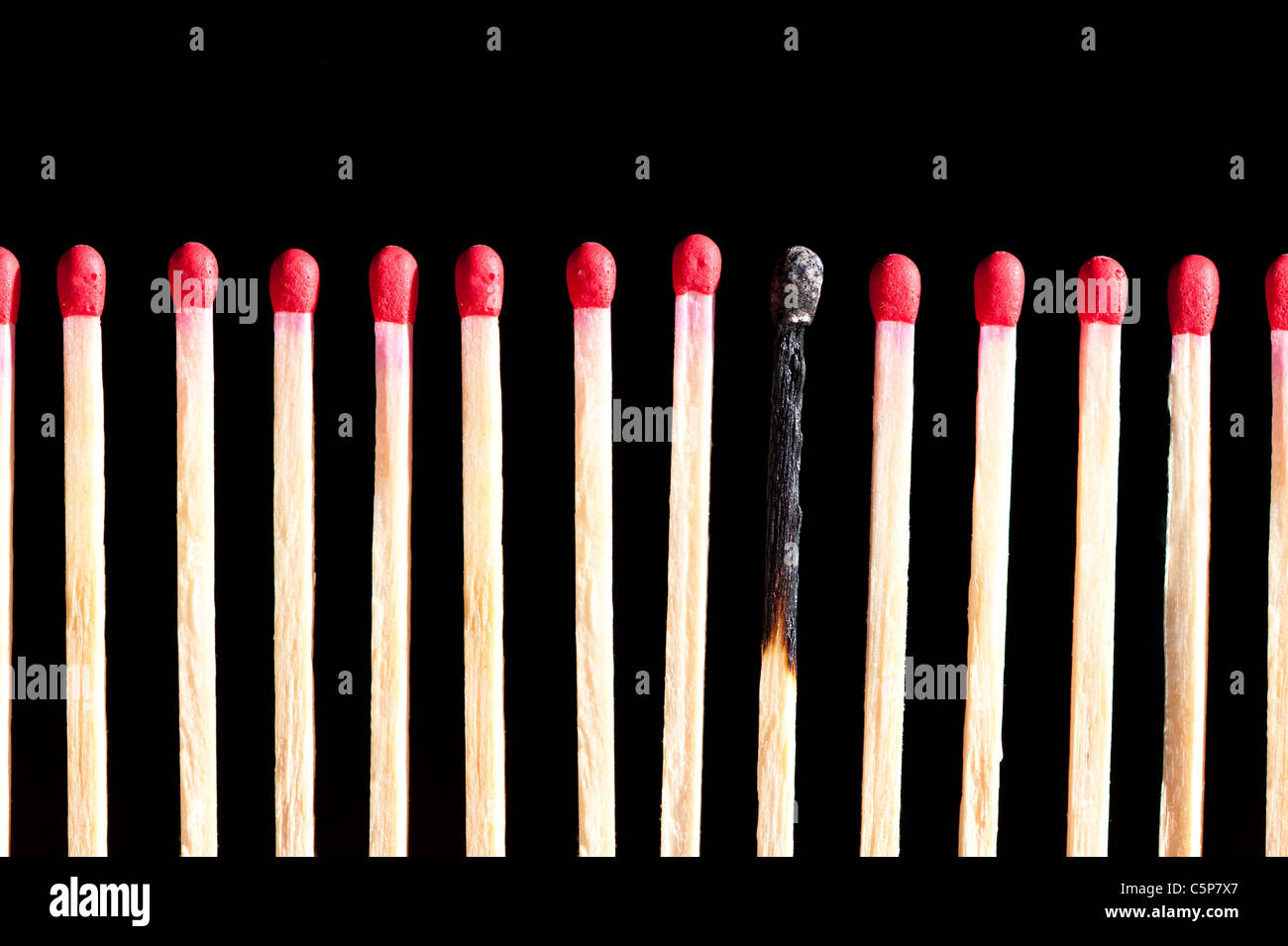 a row of matches with one burned, isolated on black background Stock ...