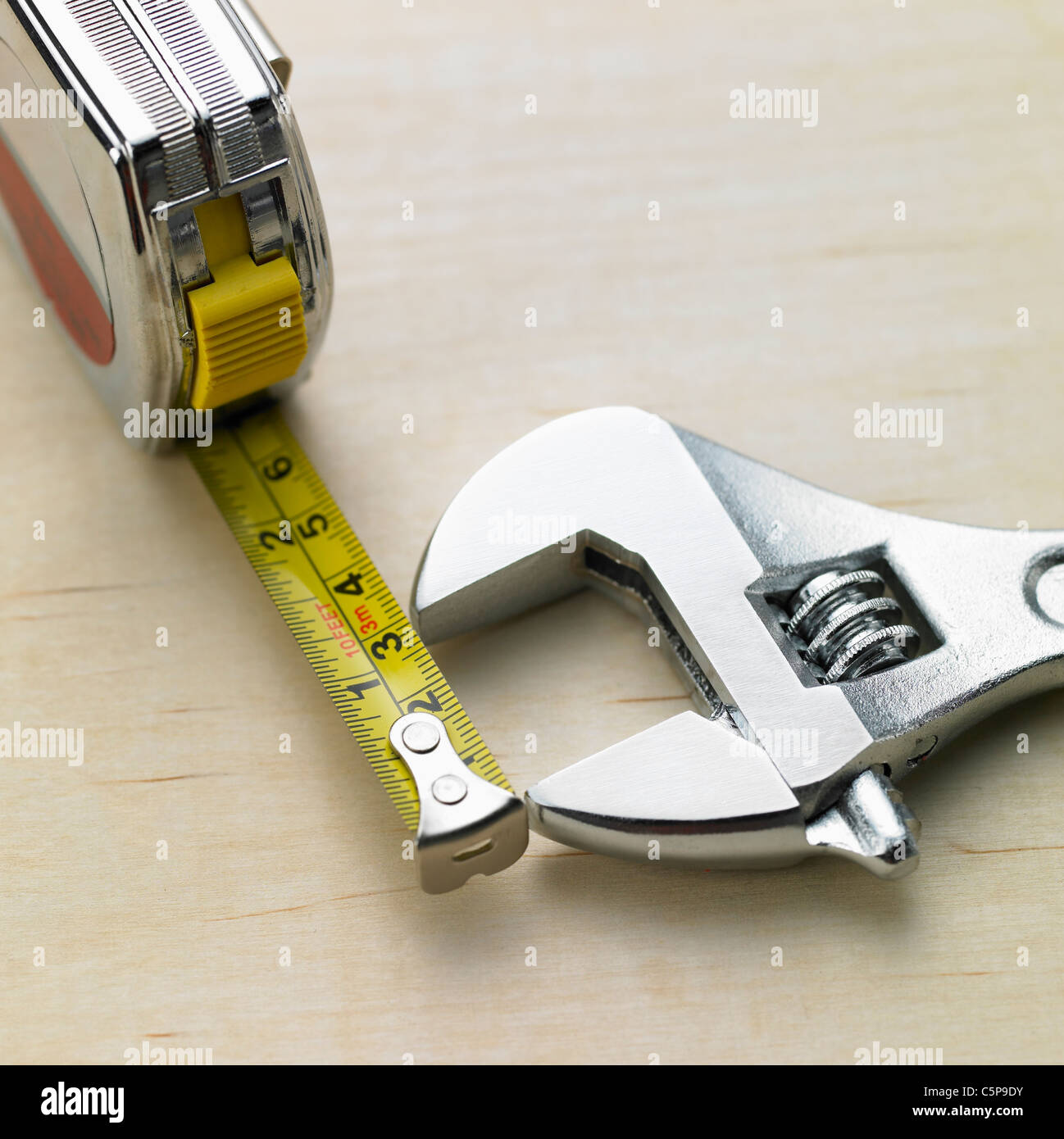 A monkey spanner and a measuring tape Stock Photo - Alamy