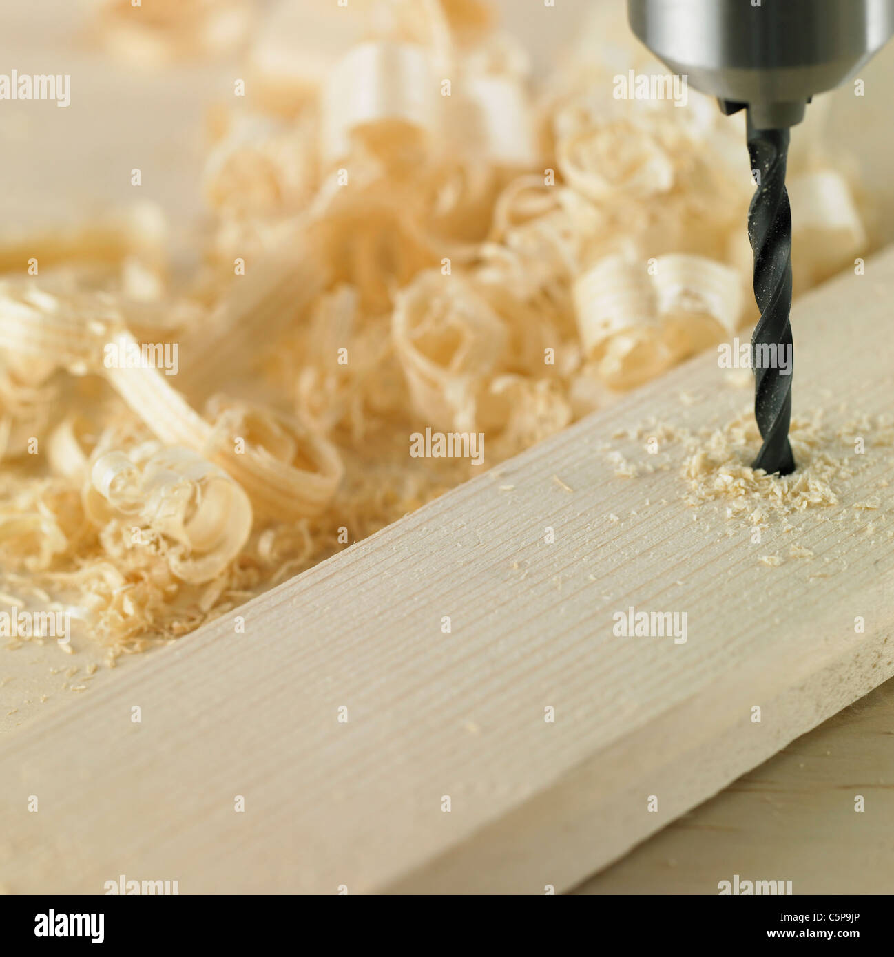 A drill drilling into wood Stock Photo - Alamy