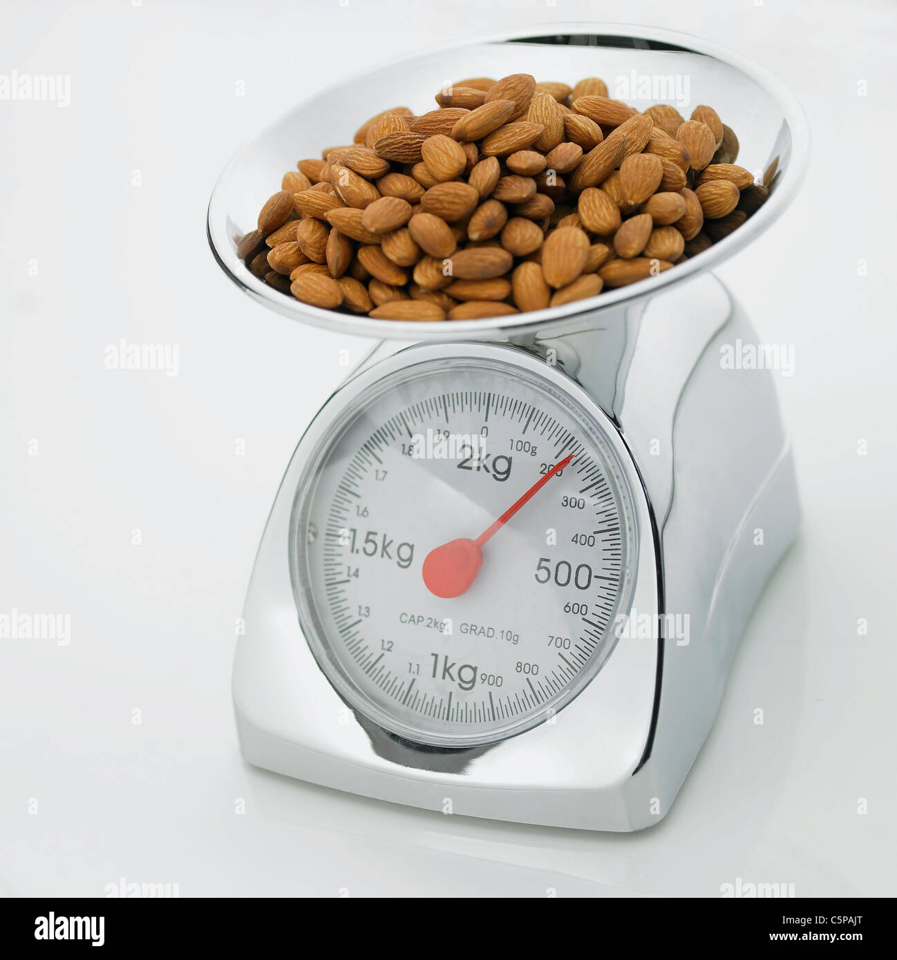 Almonds on a scale Stock Photo - Alamy