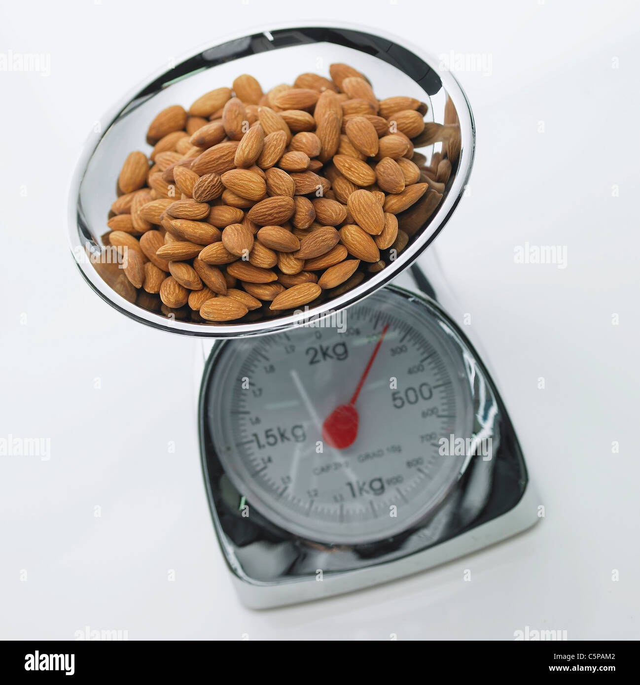 Almonds on a scale Stock Photo - Alamy
