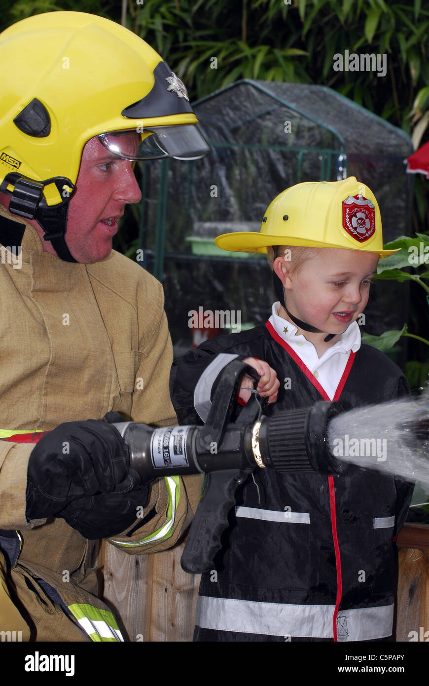 Young boy with trained firefighter aspiring to be a fireman when he ...