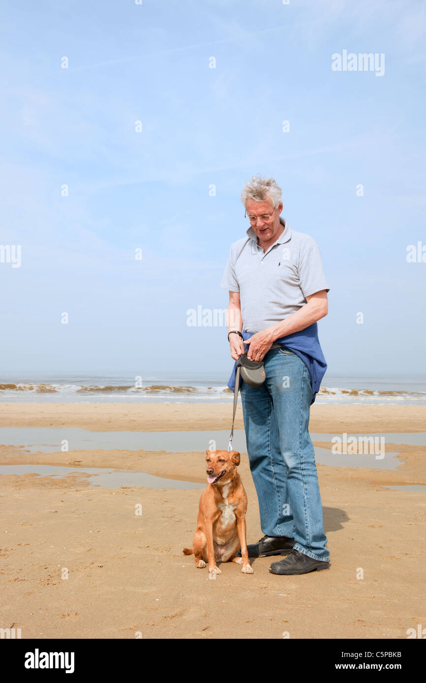 Man with little brown dog at the beach Stock Photo - Alamy