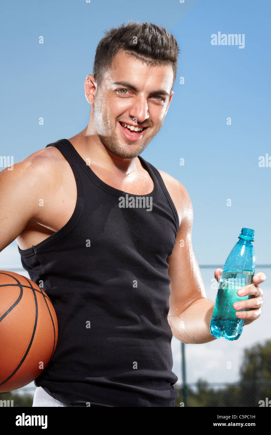 Young thirsty man drinking water on sports field Stock Photo - Alamy