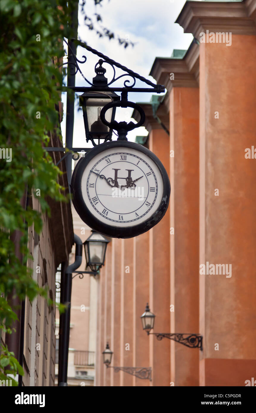 old street clock on the background of a narrow street in Stockholm ...