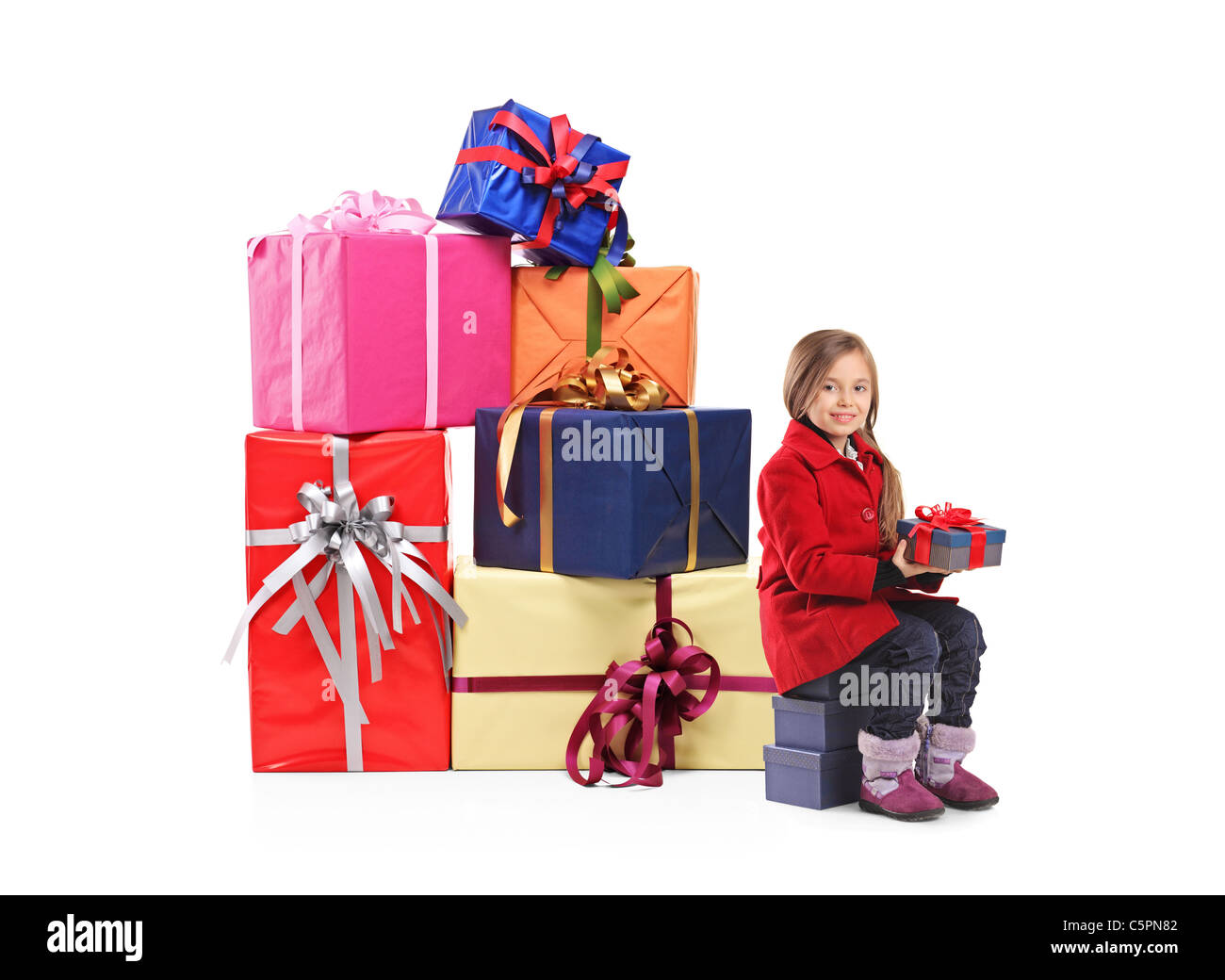 A child holding a gift next to a pile of gifts Stock Photo - Alamy