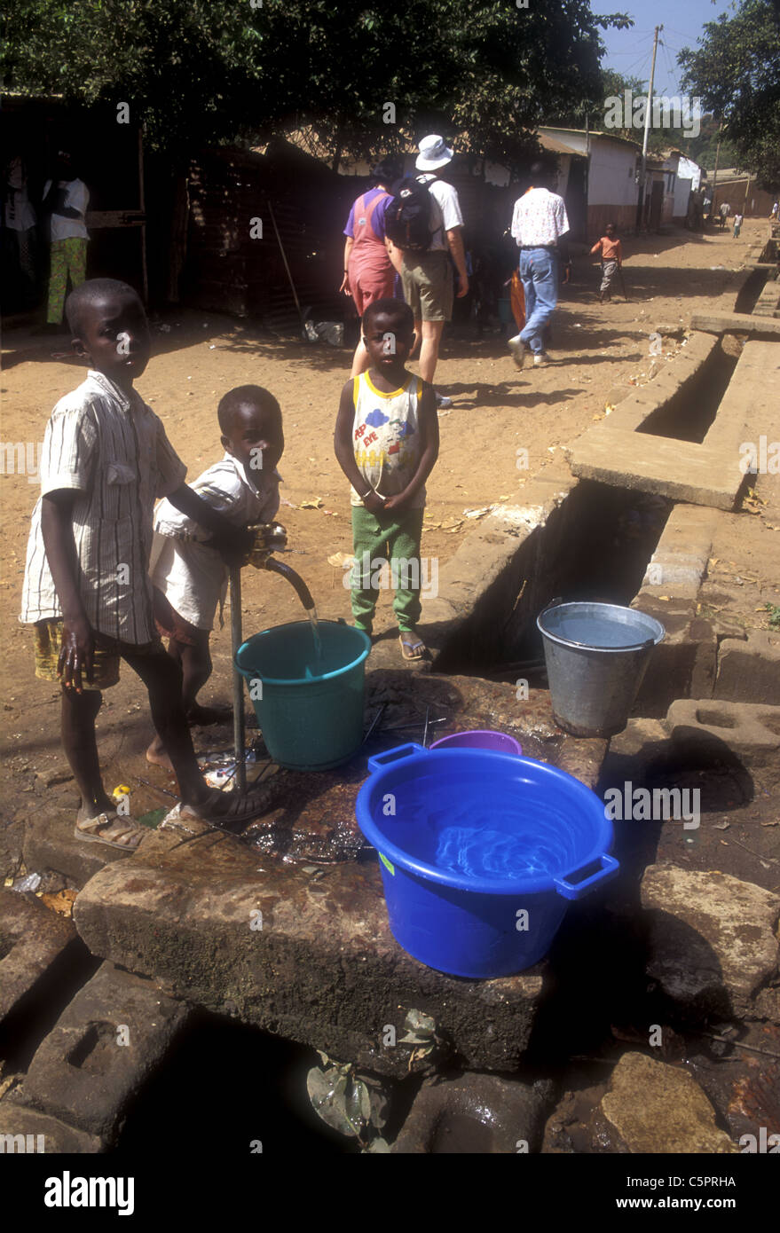 Children filling a bucket from a stand-pipe in Gambia Stock Photo - Alamy