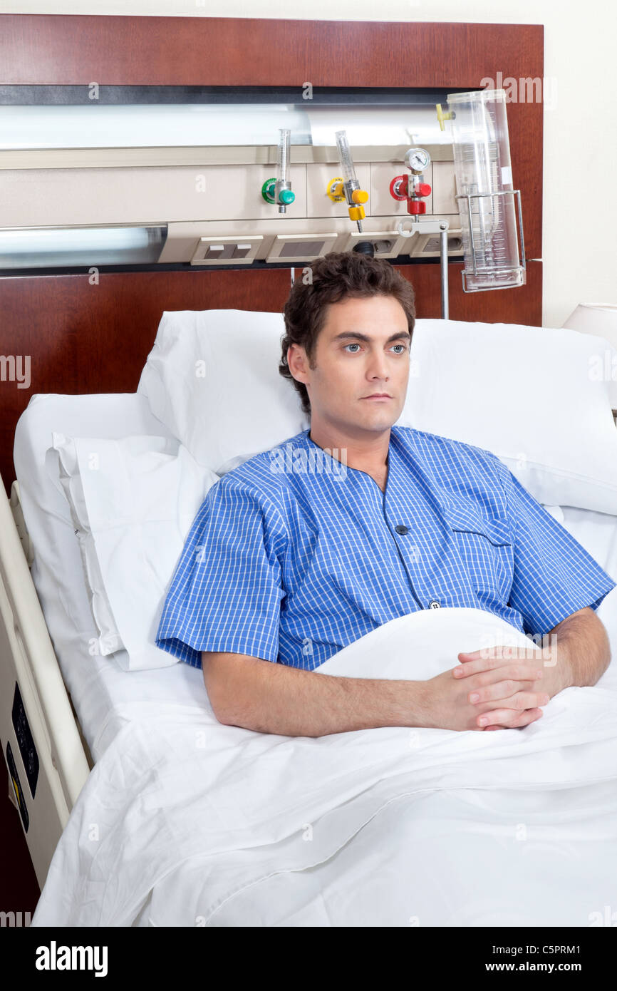 Serious patient sitting on bed in hospital Stock Photo - Alamy