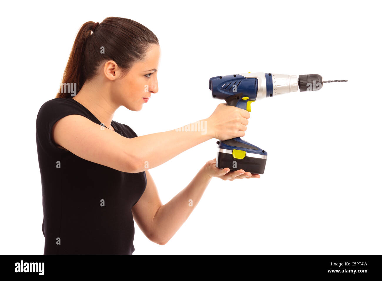 Young female dressed in black top holding a cordless electric drill on ...