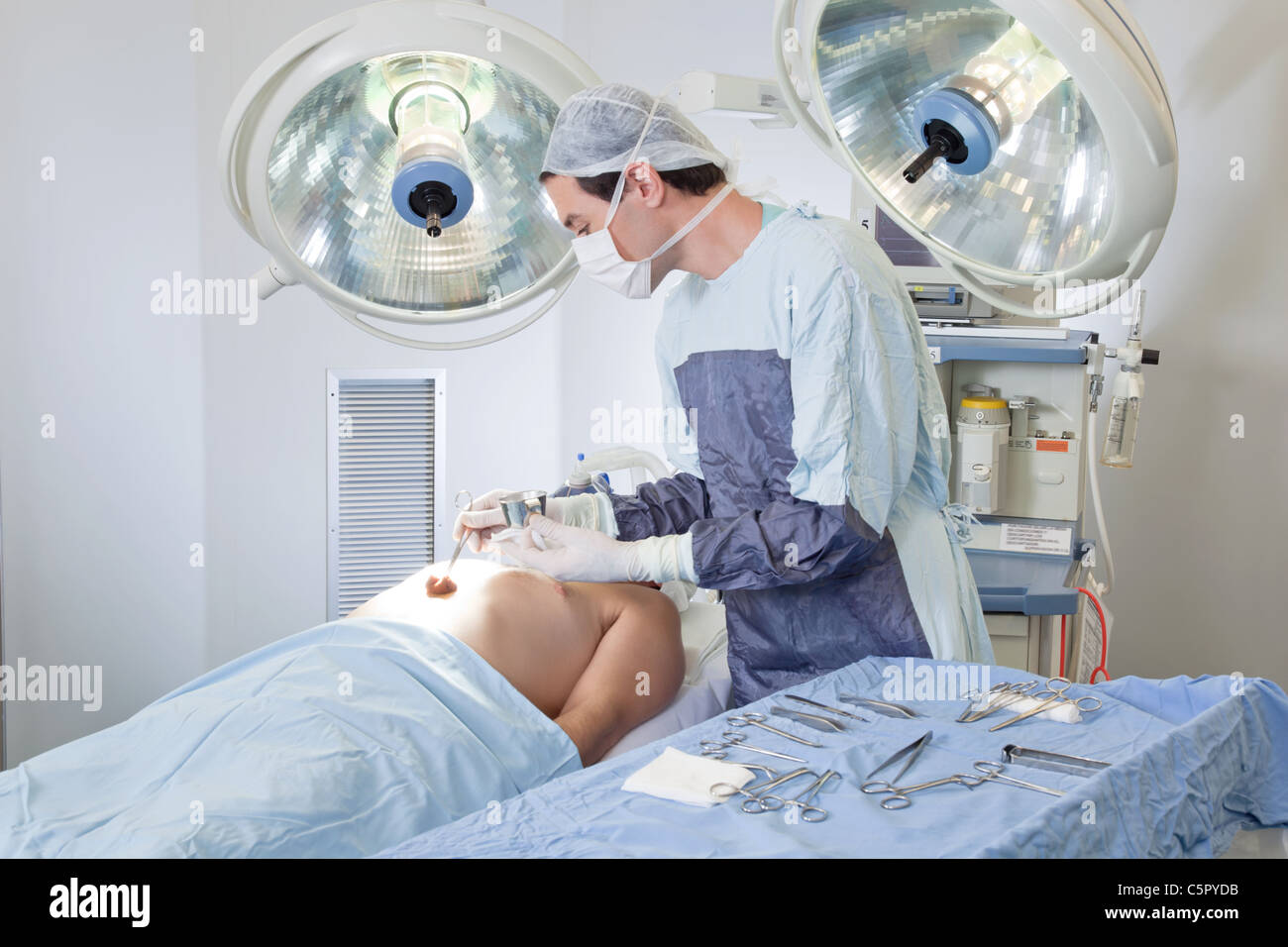 Doctor performing operation on patient in operating room Stock Photo ...