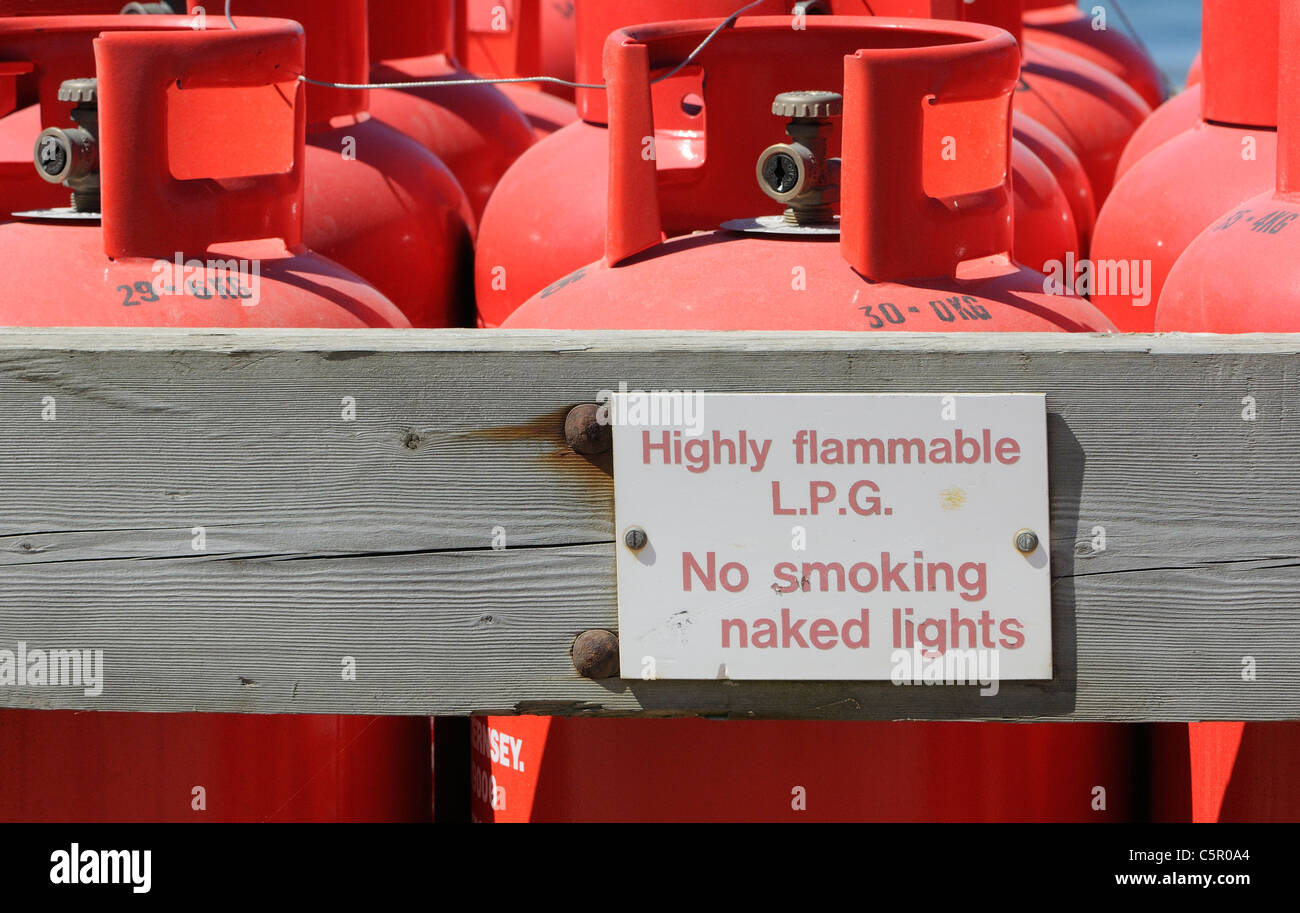 Red gas cylinders of LPG for cooking on the quay of Herm harbour. Herm ...