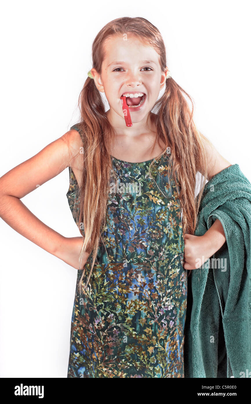 eight year old girl with a toothbrush and a towel to clean the teeth ...