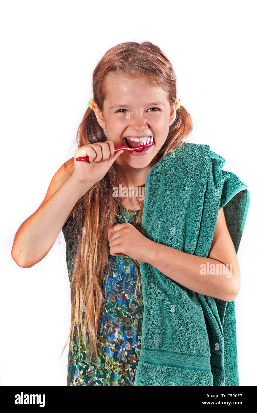eight year old girl with a toothbrush and a towel to clean the teeth ...