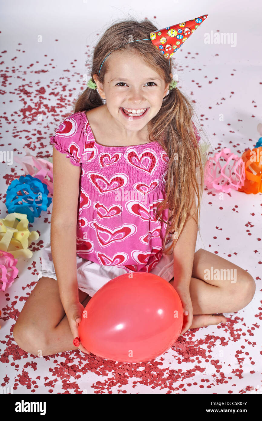 eight year old girl with party hat and trumpet on a children's festival ...