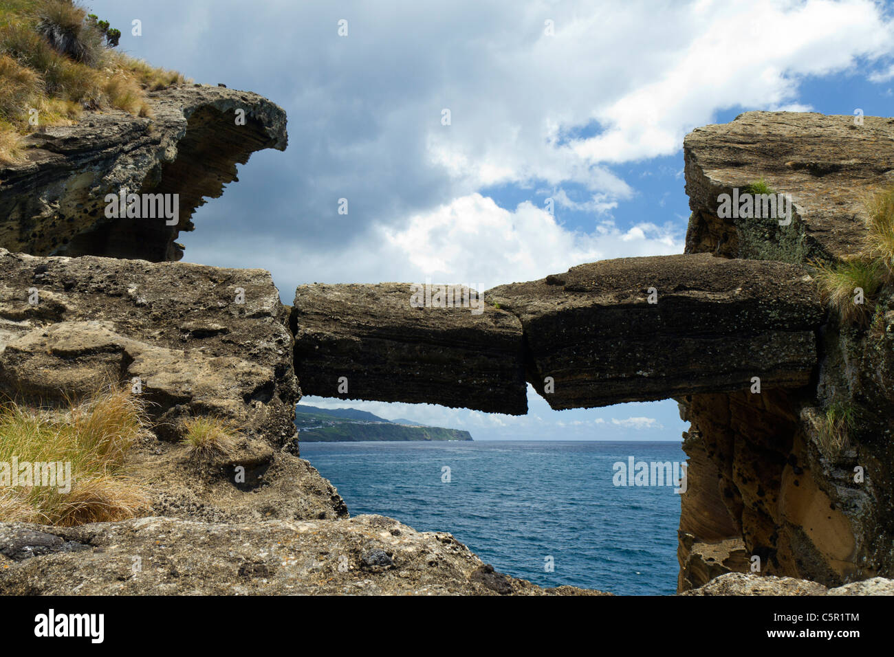 Rock bridge at Ilhéu Vila Franca, a volcanic crater lagoon islet off ...