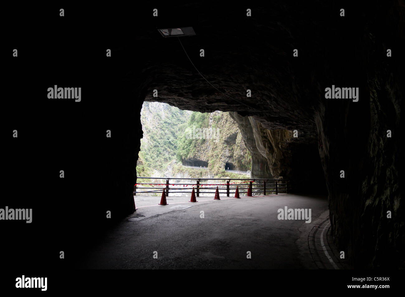 Cliffside tunnel's galleries, road under rock overhang along marble ...