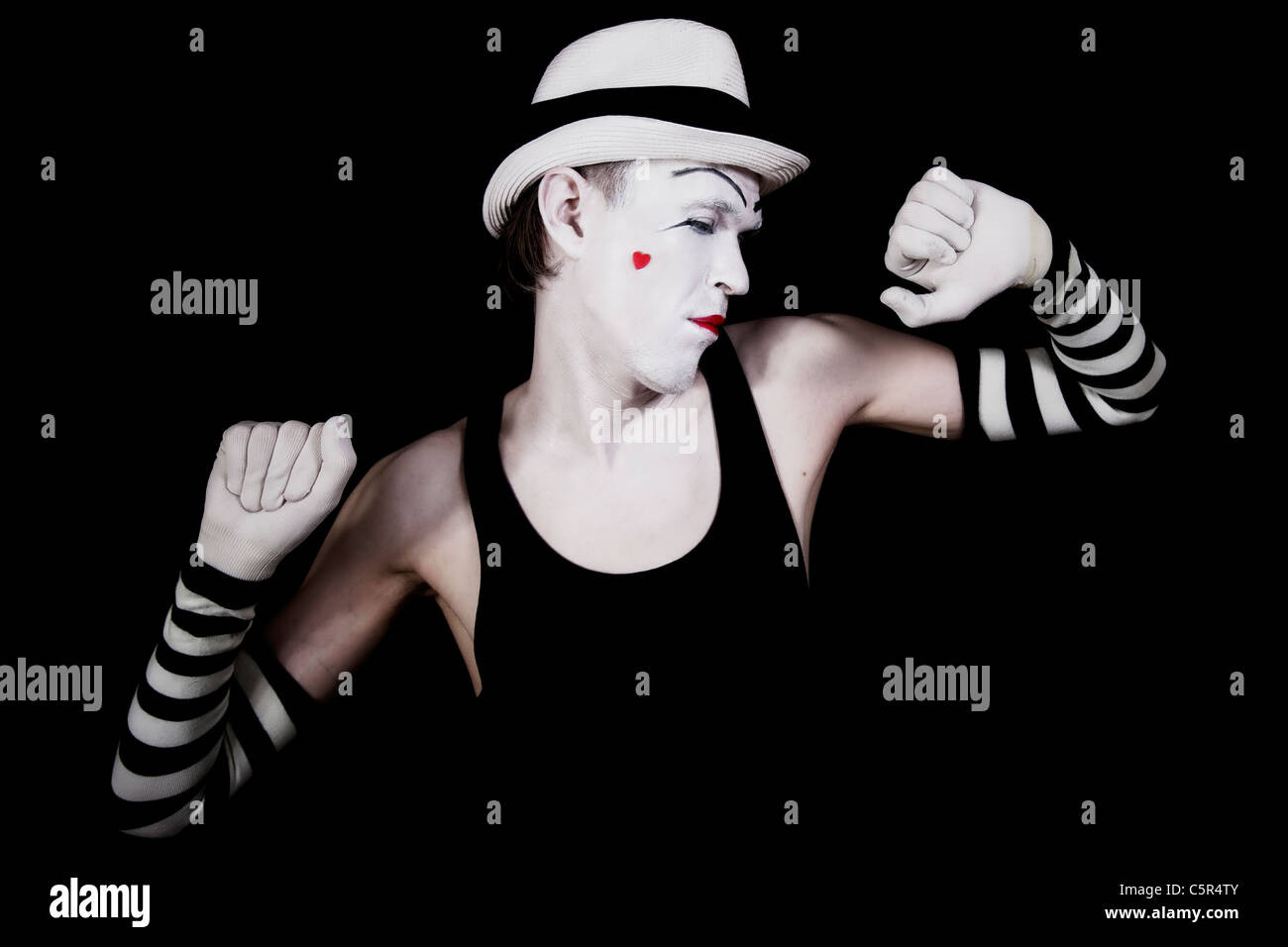 Portrait of a dancing mime in white hat with a heart on her cheek on ...
