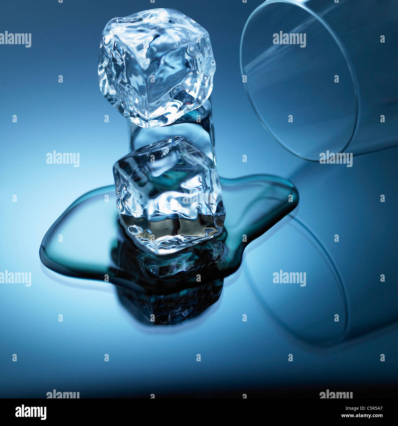 Spilled water, ice cubes and glass cup Stock Photo - Alamy