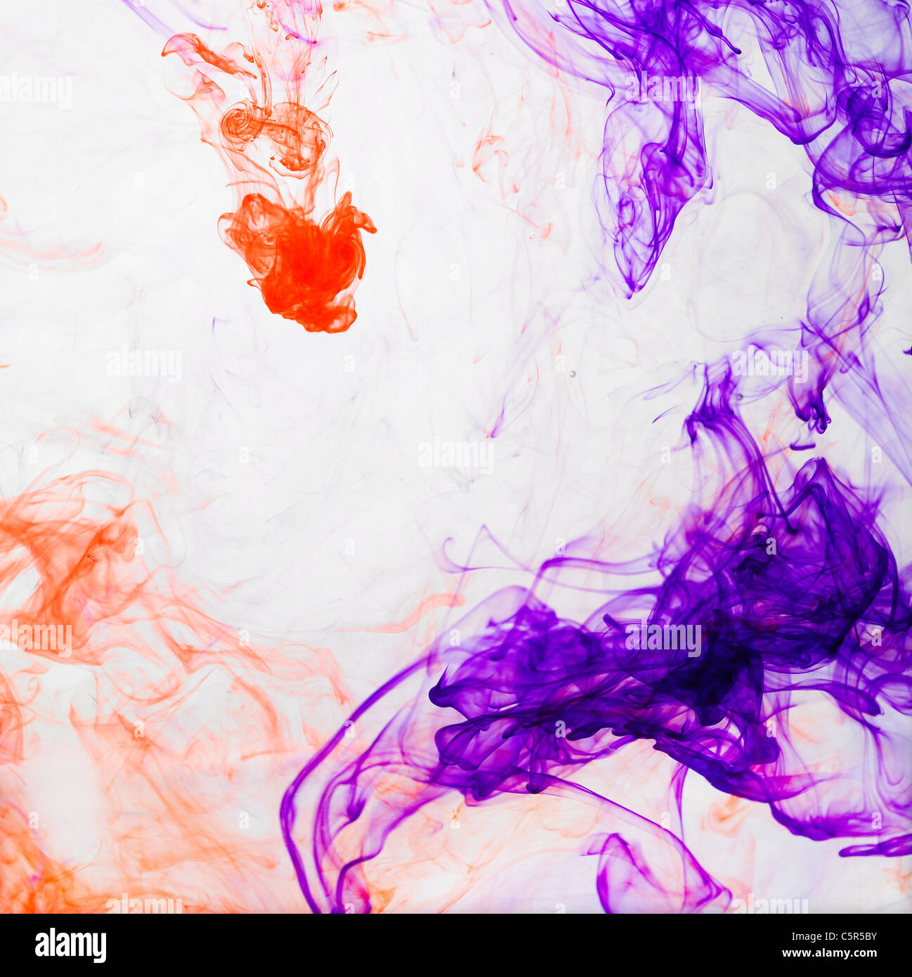 Orange and purple ink dissolving in water Stock Photo - Alamy