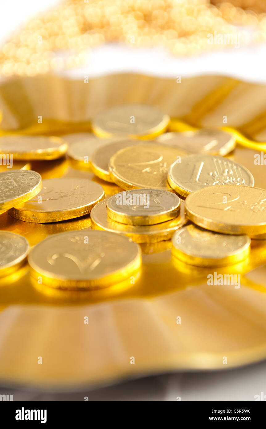 Golden chocolate euro coins on gold plate Stock Photo - Alamy