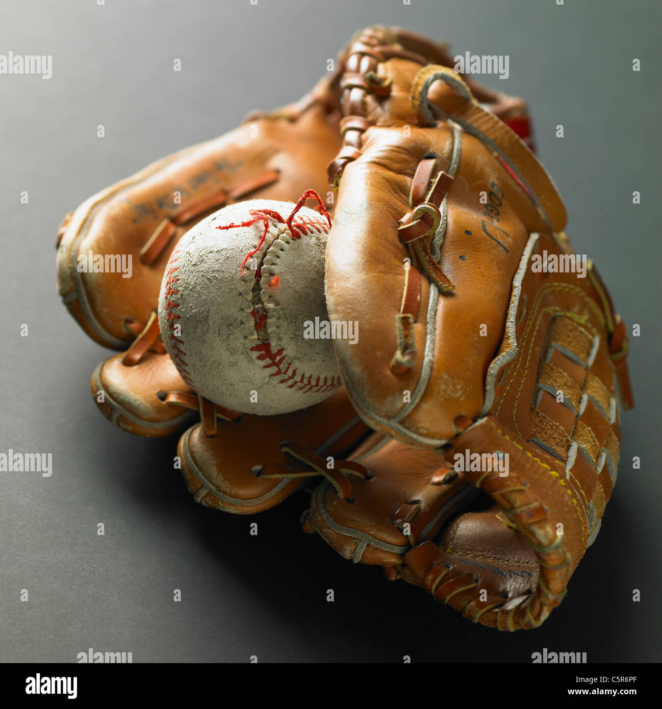 A baseball glove and a ball with its stitch ripped Stock Photo - Alamy