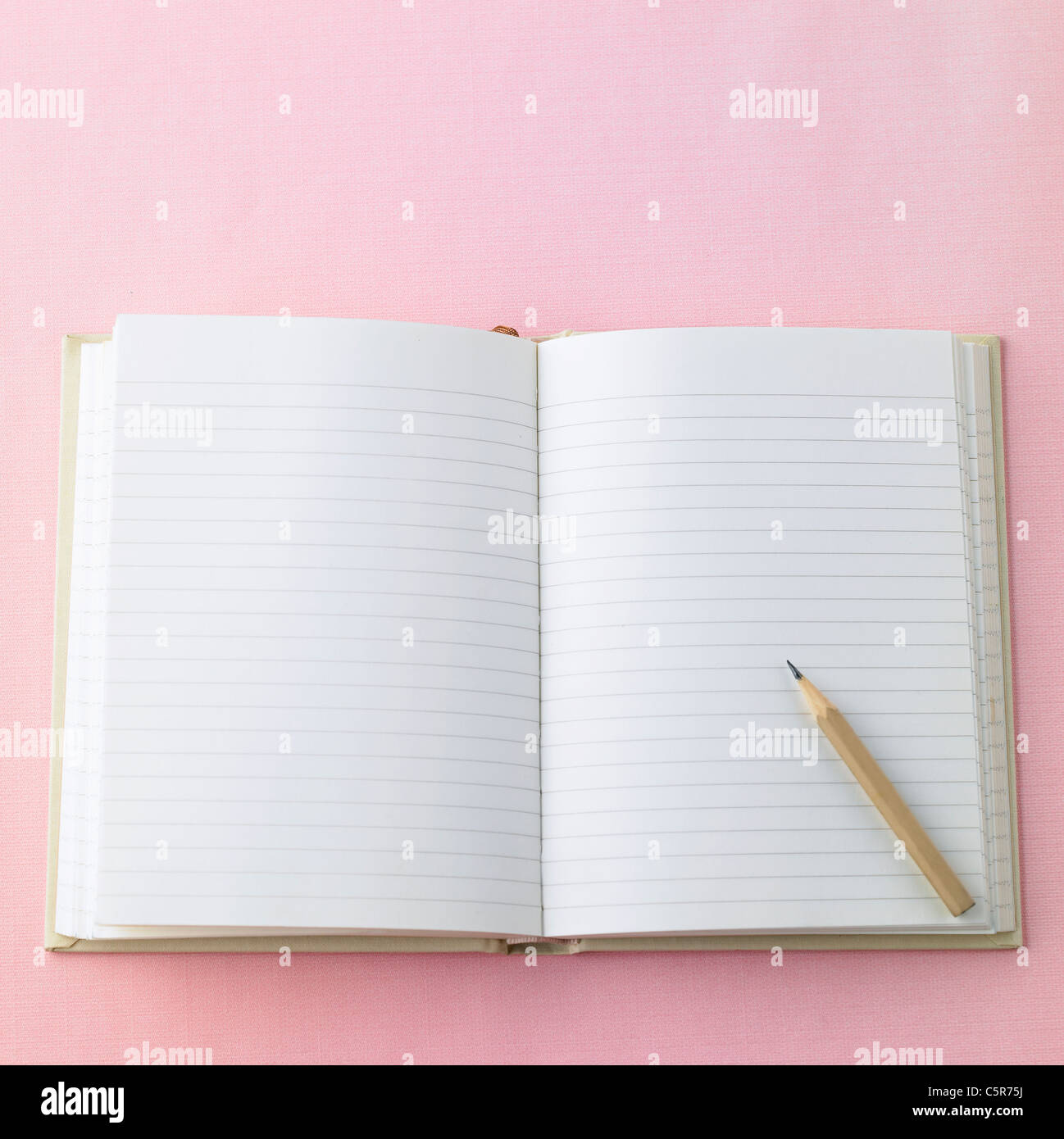 An open notebook and a pencil Stock Photo - Alamy