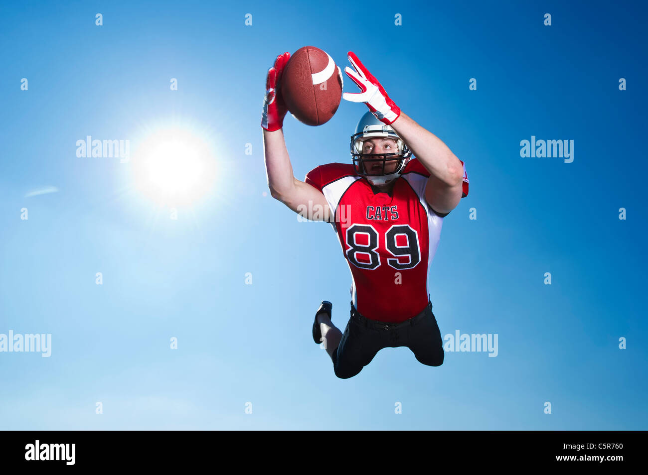 American Footballer focused on ball to make the catch Stock Photo - Alamy