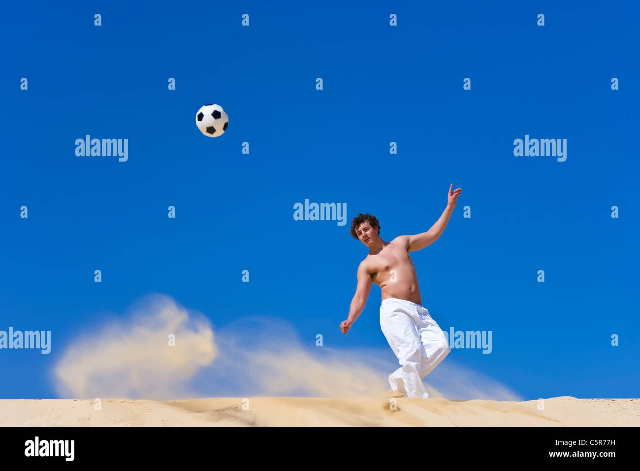 Beach soccer player passing ball Stock Photo - Alamy