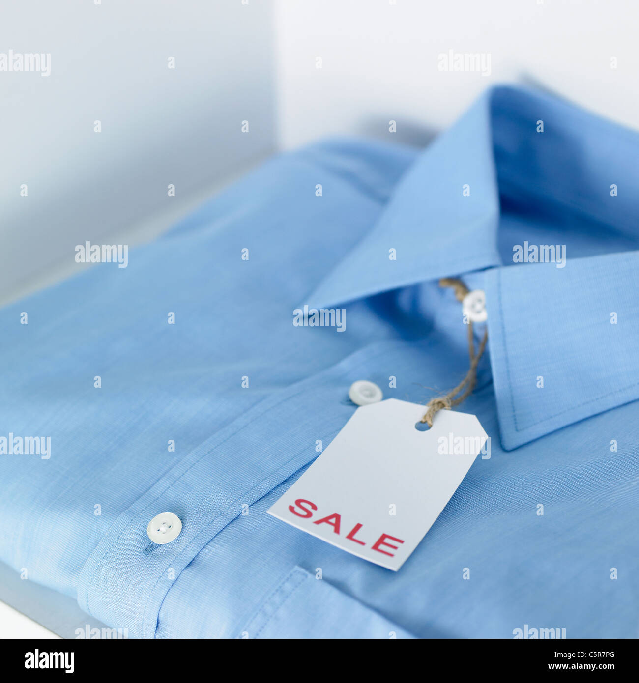 A shirt with sales tag on in showcase Stock Photo - Alamy