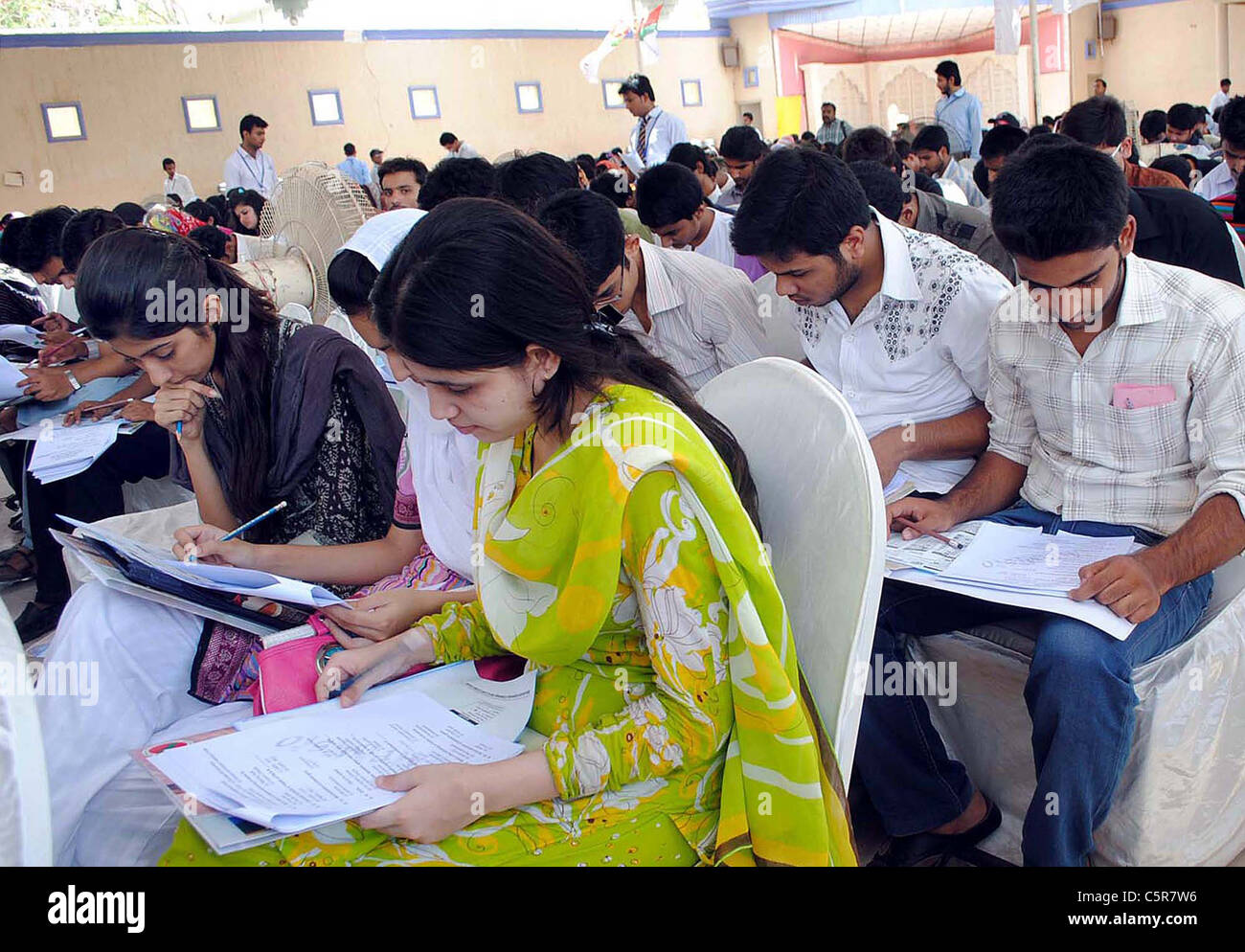 Students solve papers during pre-entry test for admissions in medical ...
