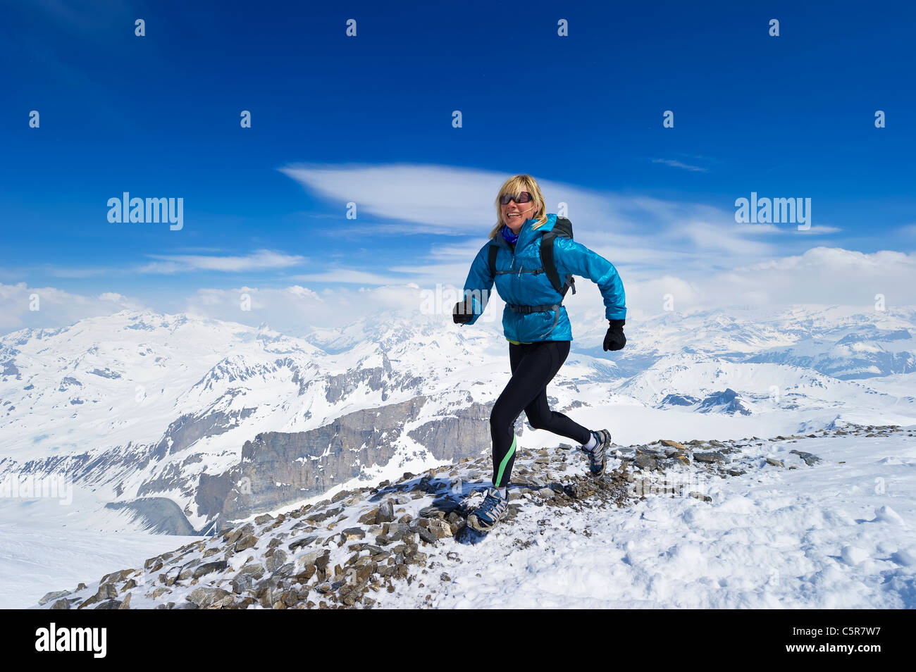 Women enjoying a run across a snowy alpine mountain range Stock Photo ...