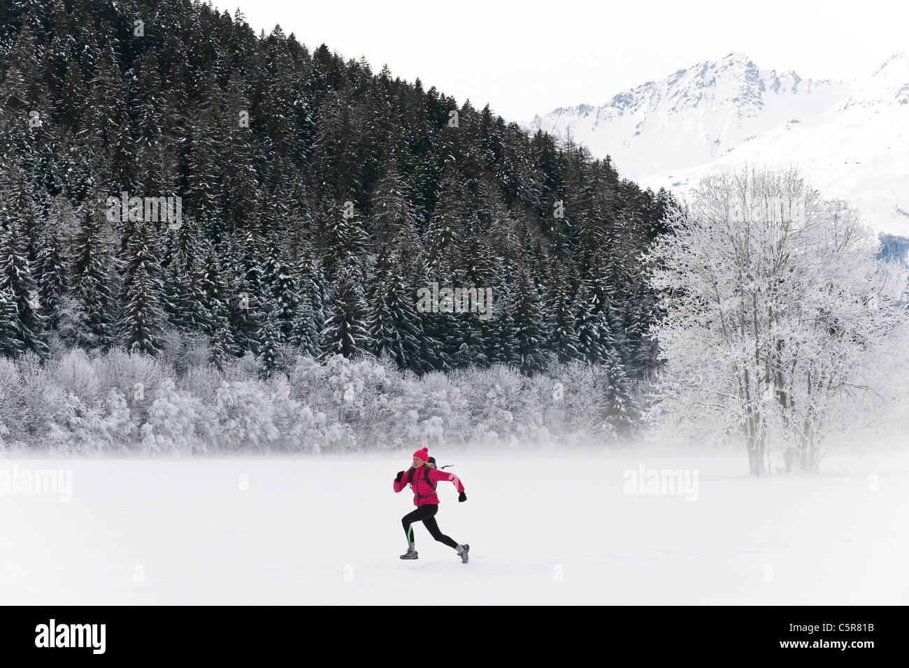A runner sprinting through a frozen winter landscape Stock Photo - Alamy