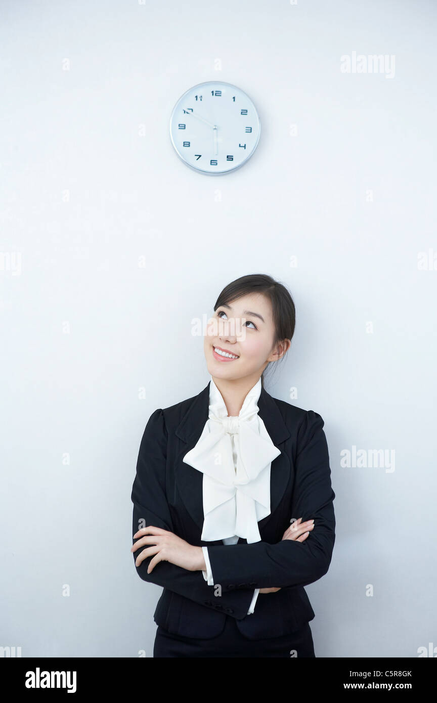 A business woman looking at a clock on the wall Stock Photo - Alamy