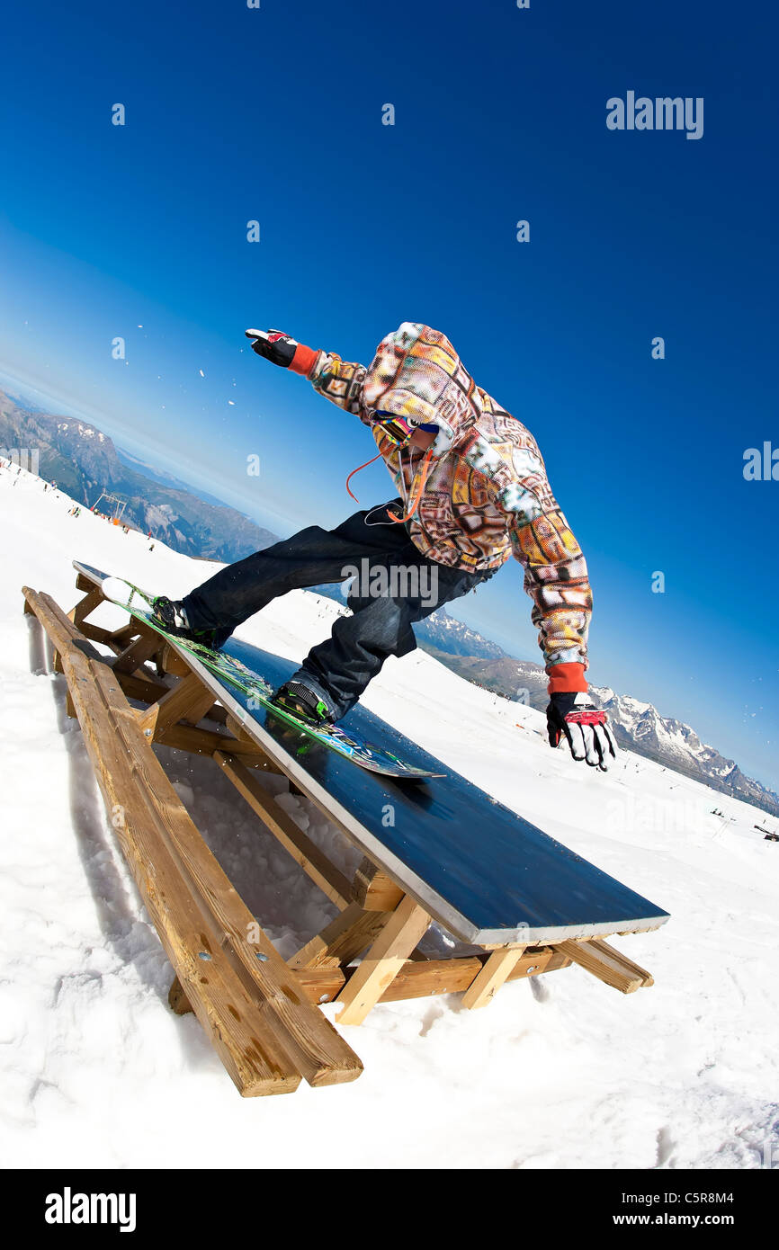 A snowboarder slides a picnic table on a mountainside Stock Photo - Alamy