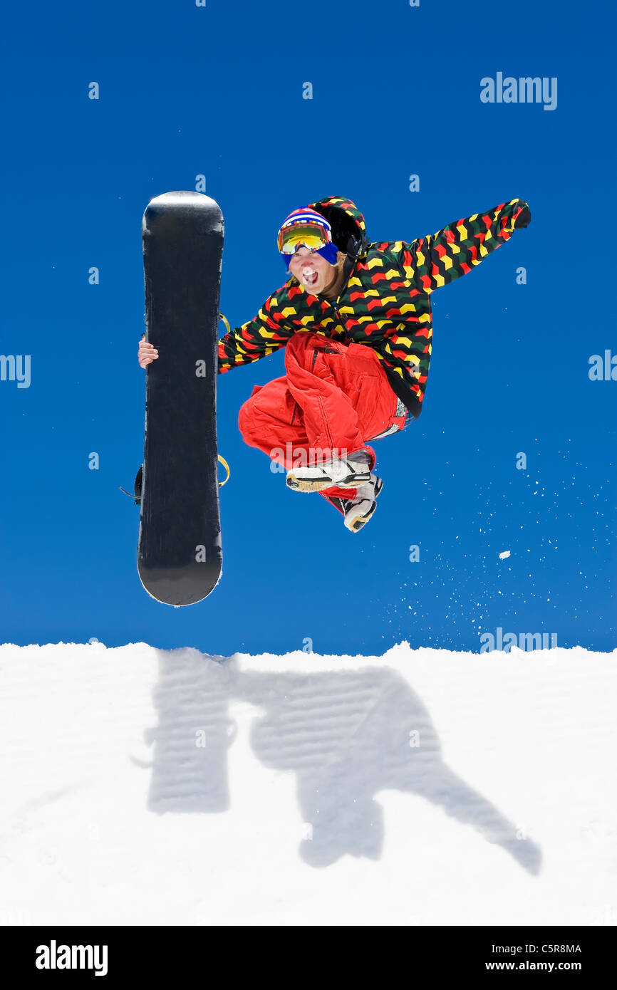 A snowboarder leaps from the side of a half pipe in celebration Stock ...