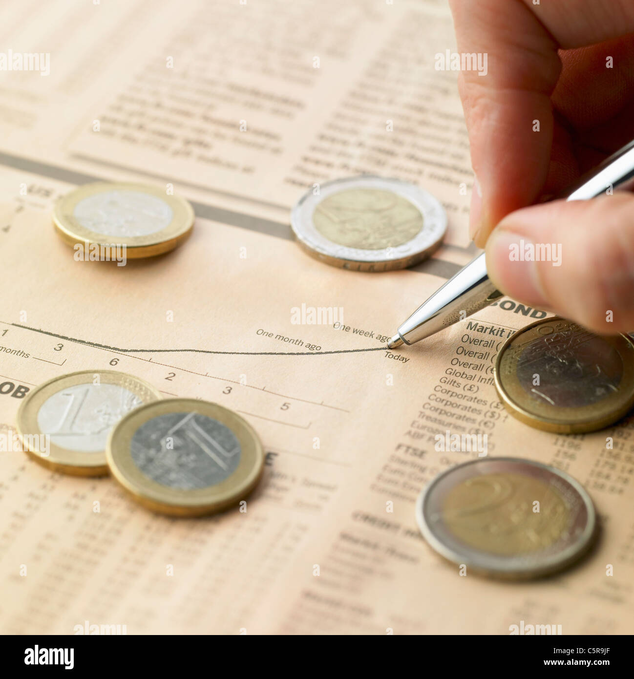 A person's hand writing on a newspaper Stock Photo - Alamy