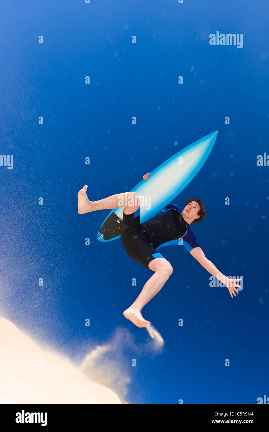A happy surfer leaps from a sand dune Stock Photo - Alamy