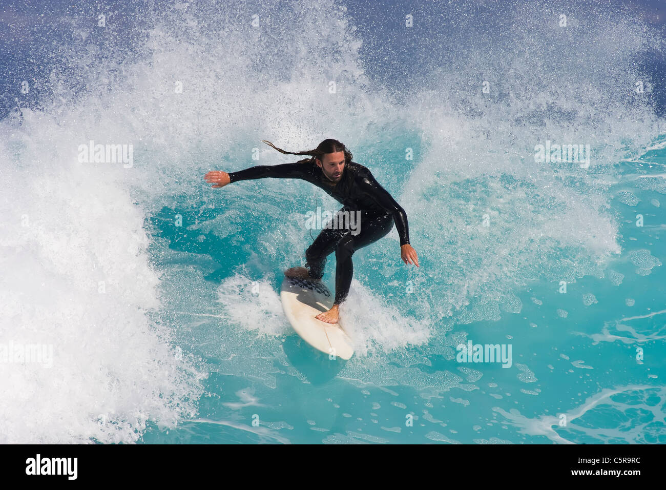 Surfer balanced riding beautiful blue wave Stock Photo - Alamy