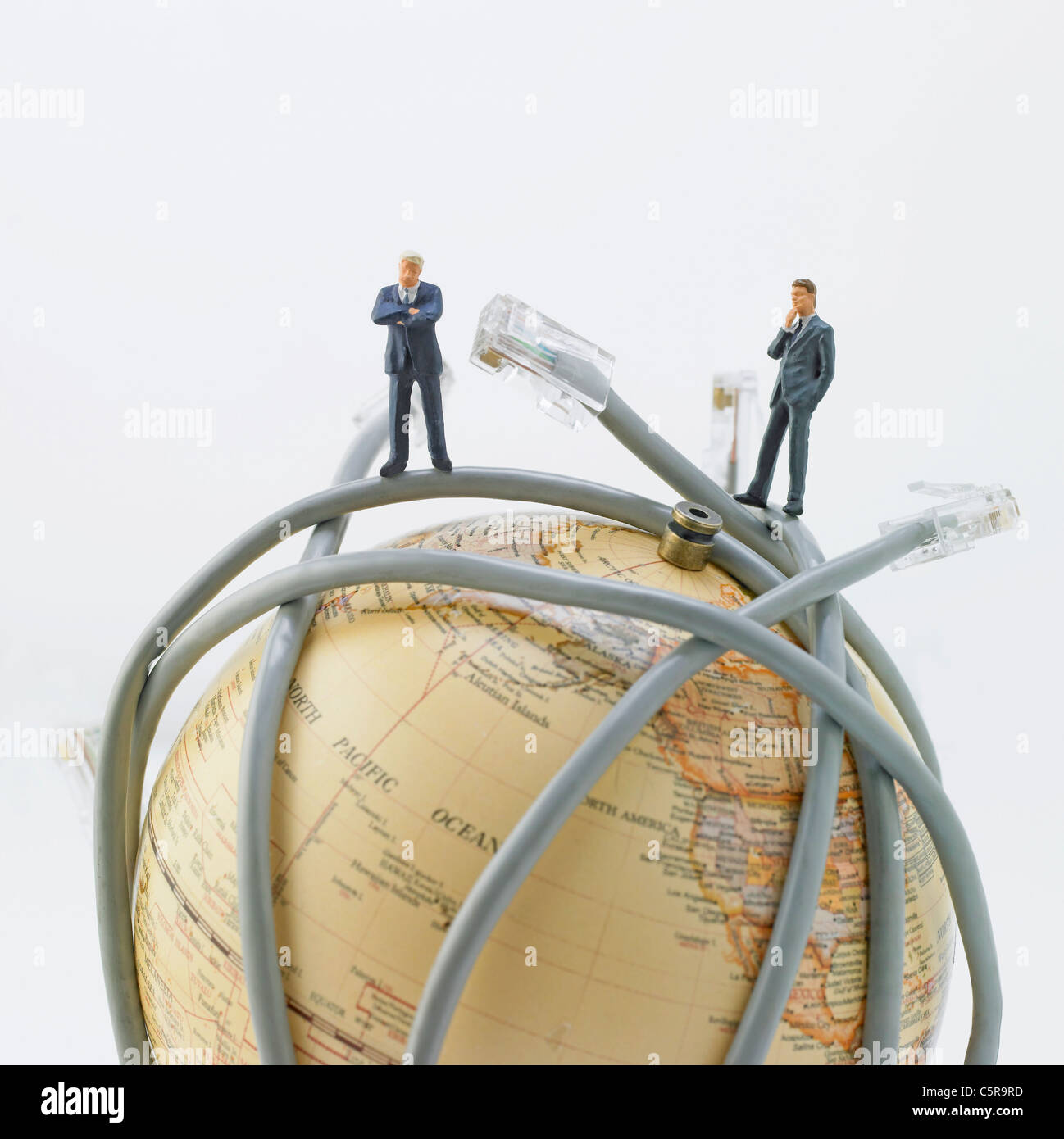 A globe wrapped by cables and figurines on it Stock Photo - Alamy