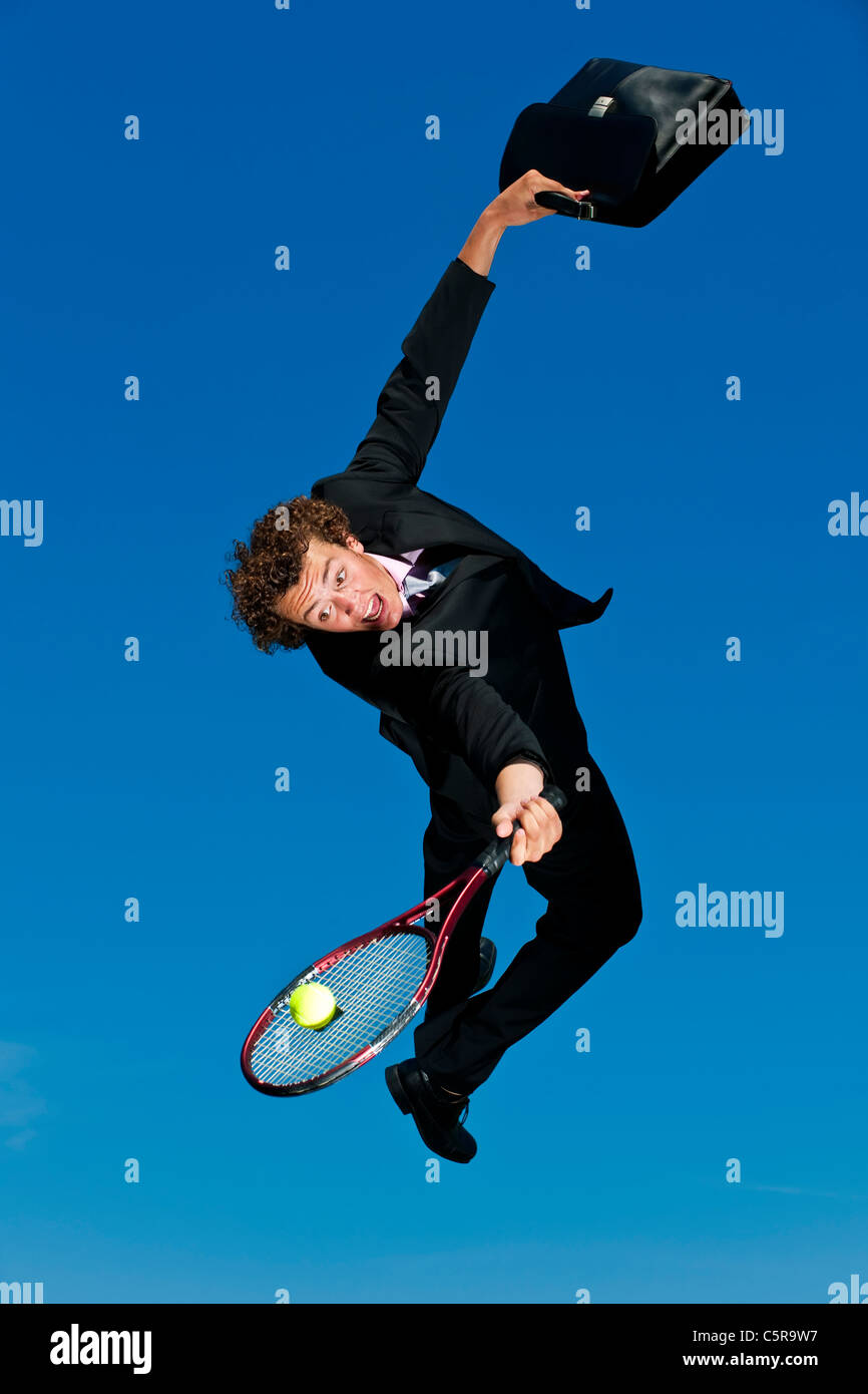 A suited businessman stretches for tennis ball Stock Photo - Alamy
