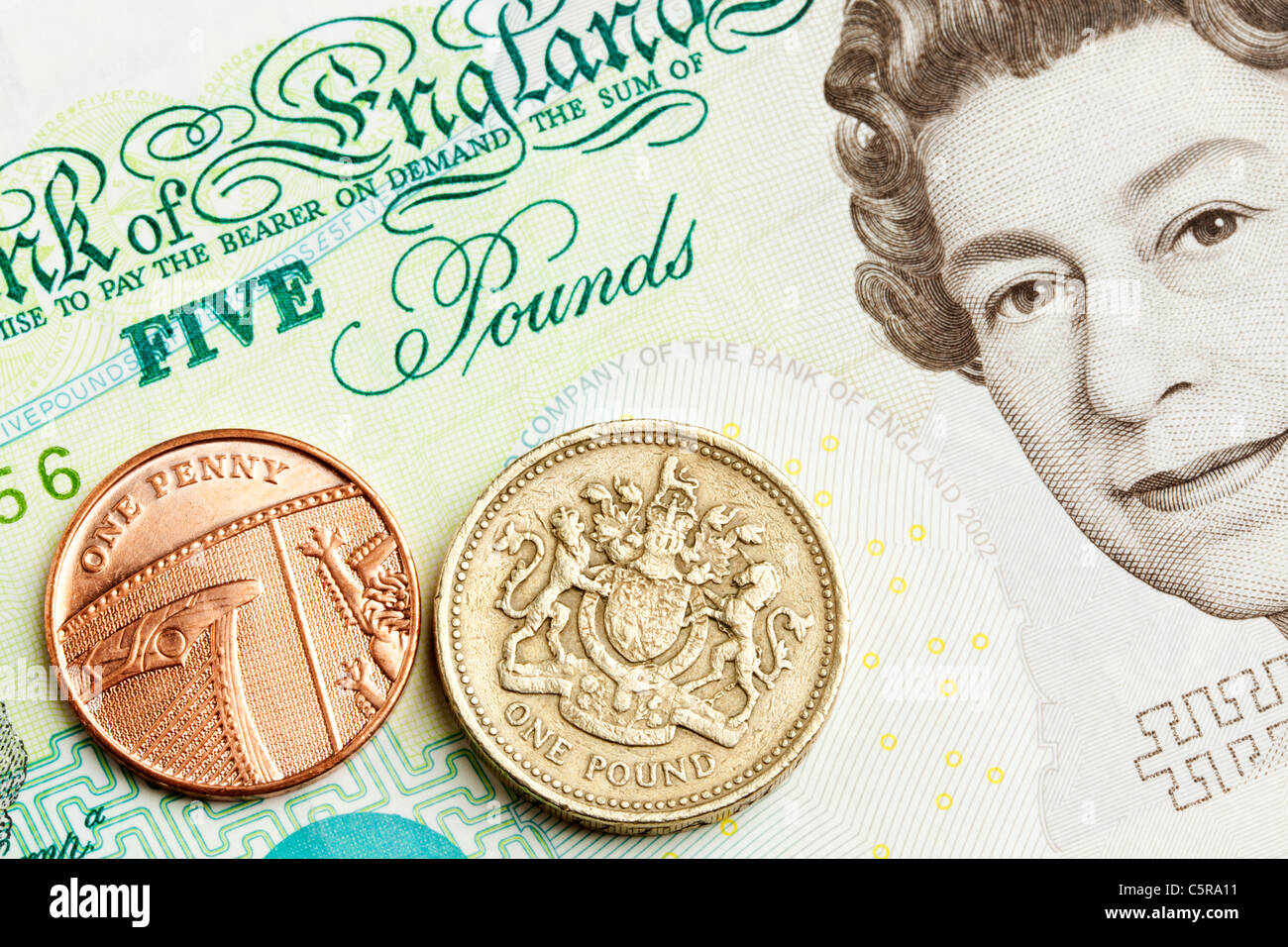 British penny and pound coins on five pound bill Stock Photo - Alamy