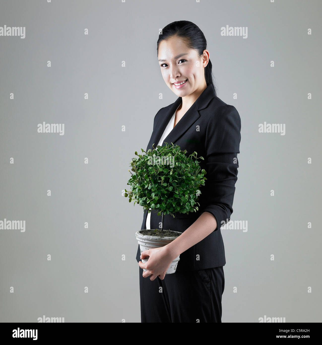 A woman holding a flower pot Stock Photo - Alamy