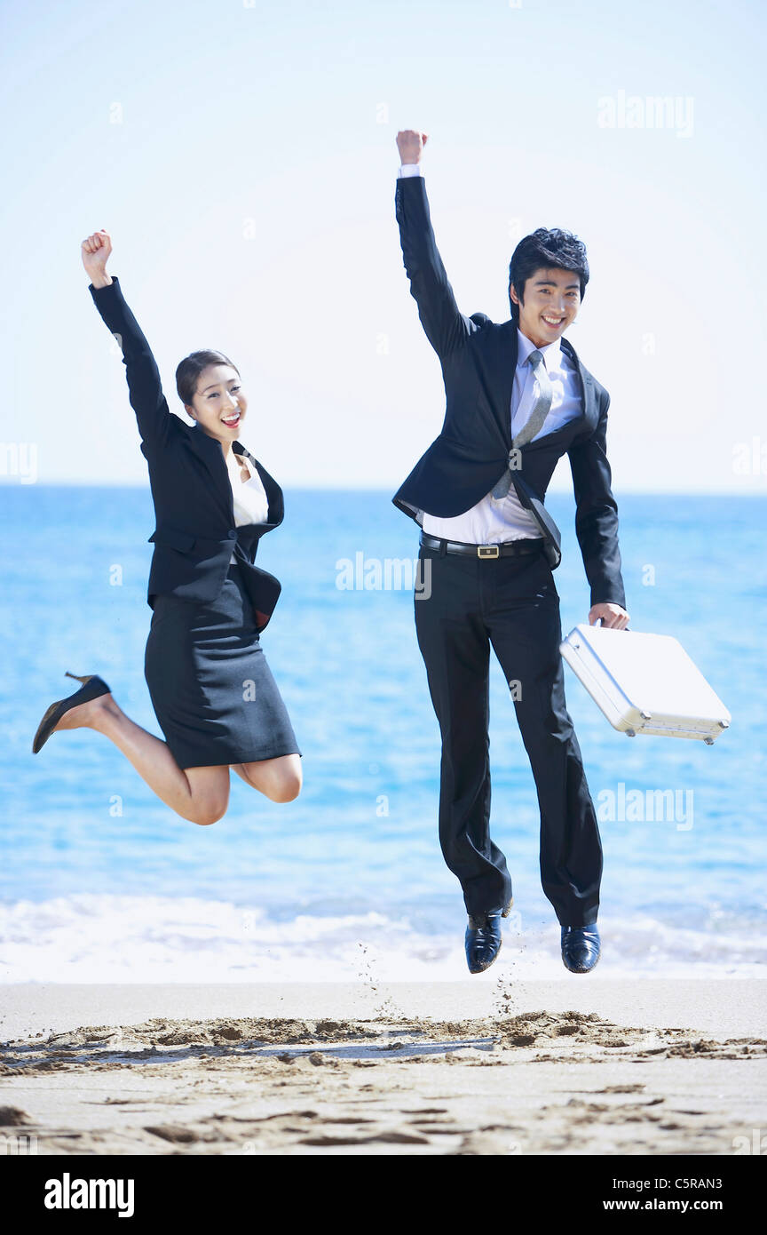 Two people jumping together at the beach Stock Photo - Alamy